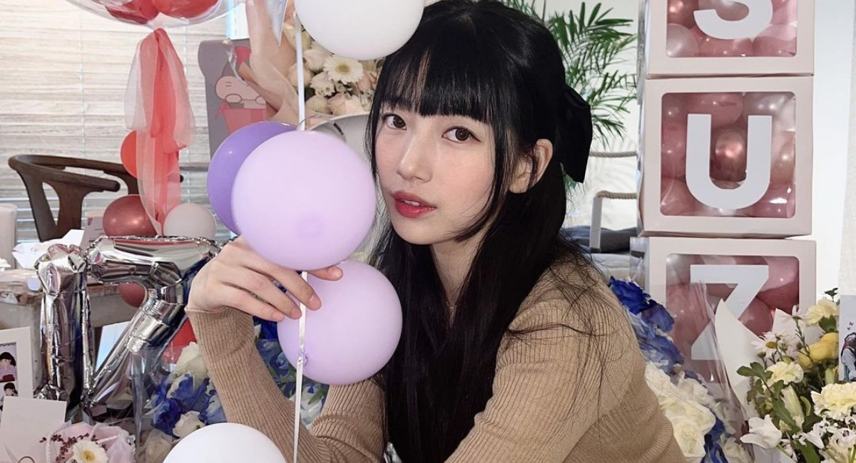 Suzy thanks fans for their birthday wishes by posing in room full of ...